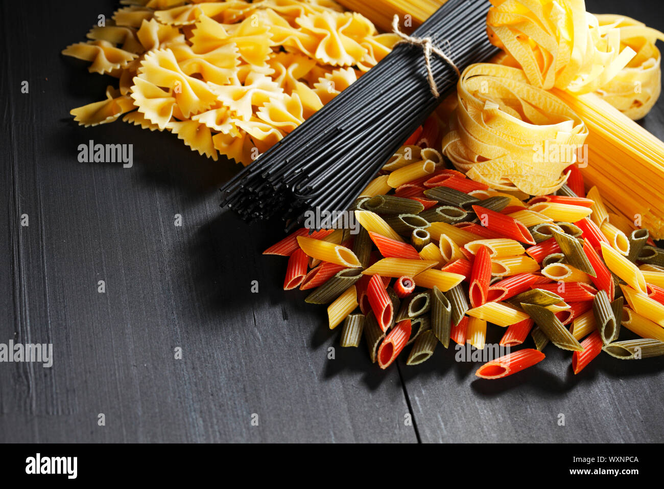 Variety of types and shapes of Italian pasta on black table Stock Photo ...