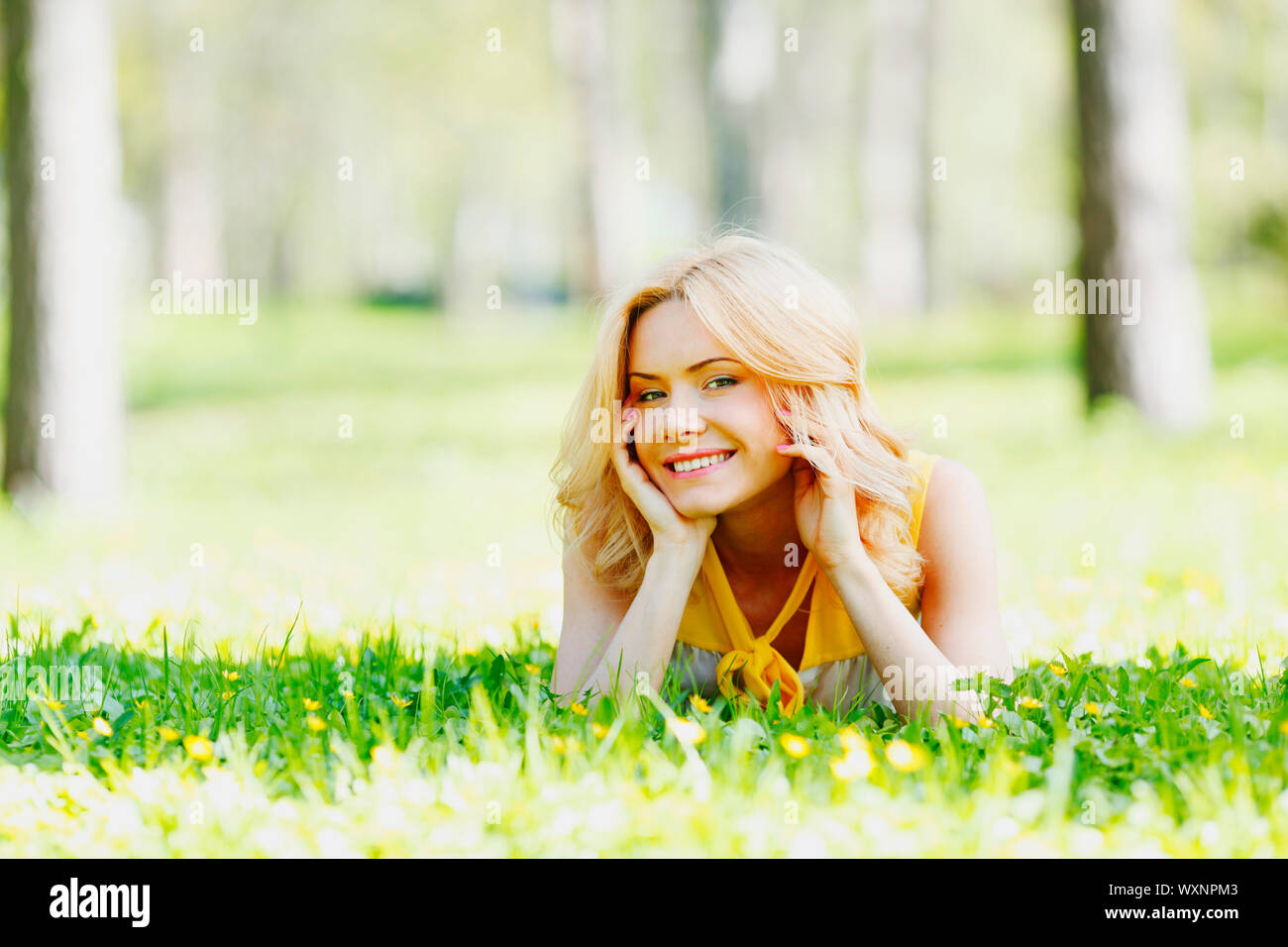Happy young woman lying on grass Stock Photo - Alamy