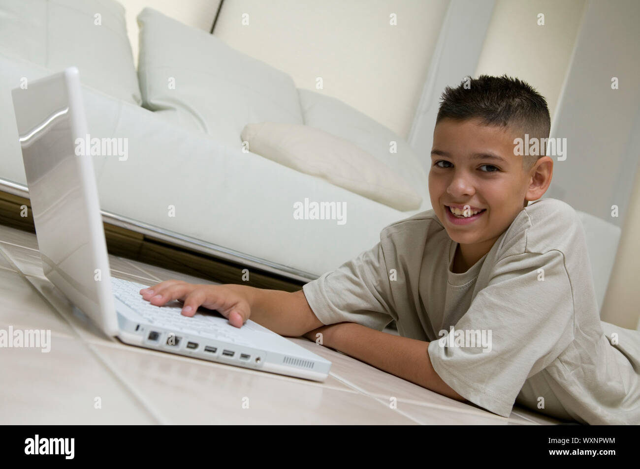 Boy Using Laptop on Living Room Floor Stock Photo - Alamy