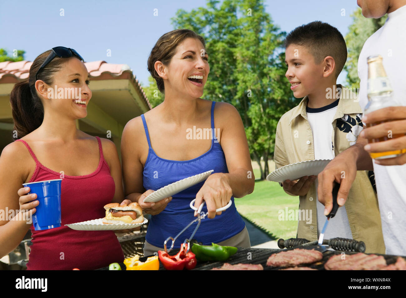 Family Gathered Around Grill Stock Photo - Alamy