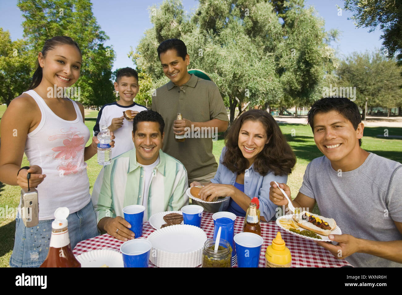 Family Gathered Around Picnic Table Stock Photo - Alamy