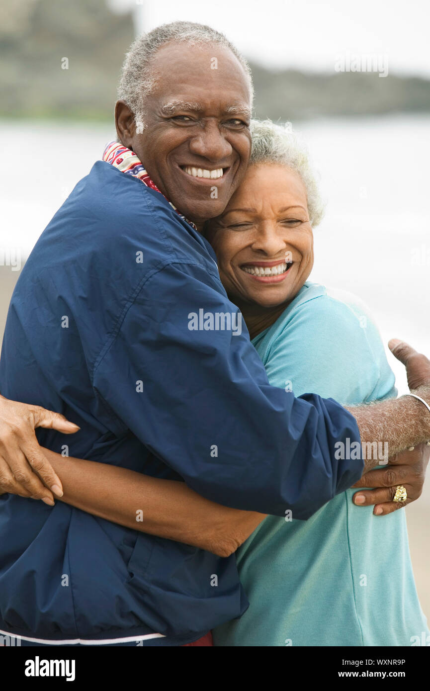 Mature Couple Hugging on Beach Stock Photo - Alamy