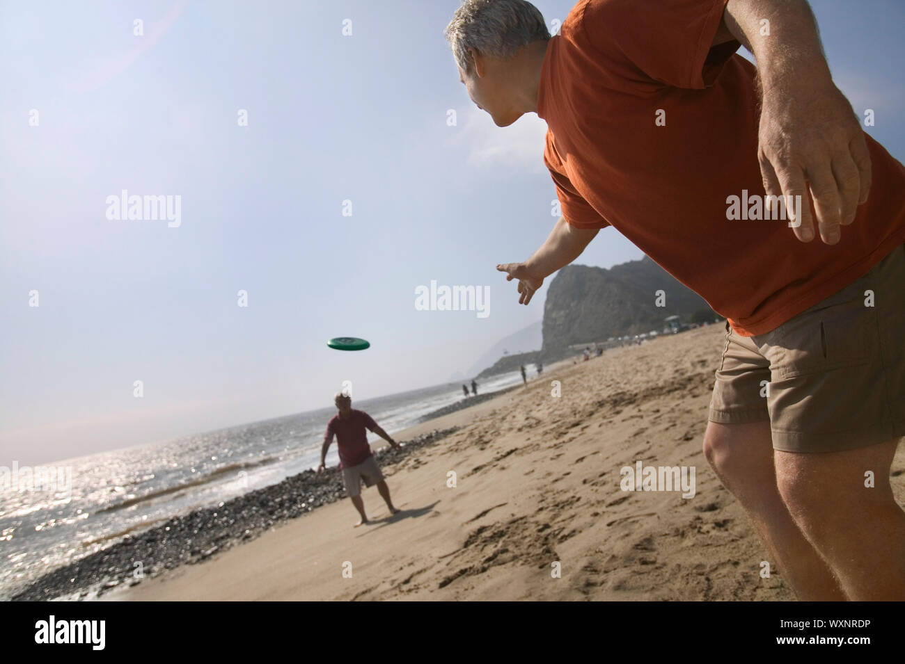 Two Friends Throwing Frisbee on Beach Stock Photo - Alamy