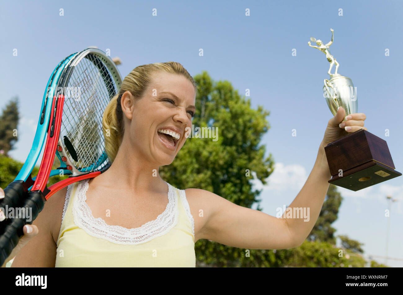 Woman with Tennis Rackets and Trophy Stock Photo - Alamy