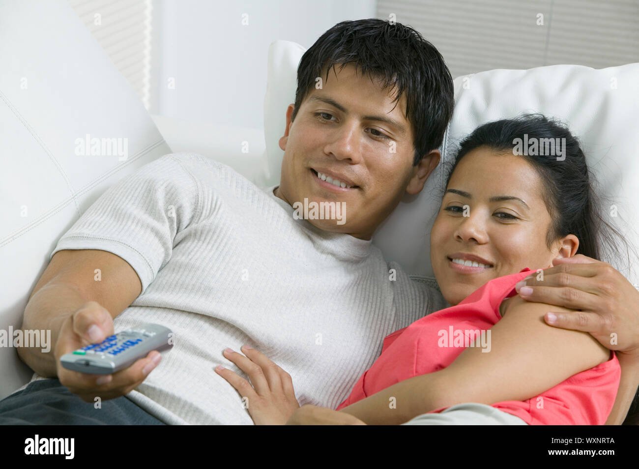 Couple on Couch with Remote Control Stock Photo - Alamy