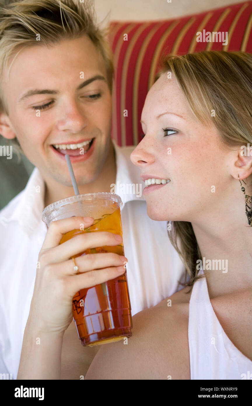 Couple Sharing Drink Poolside Stock Photo - Alamy