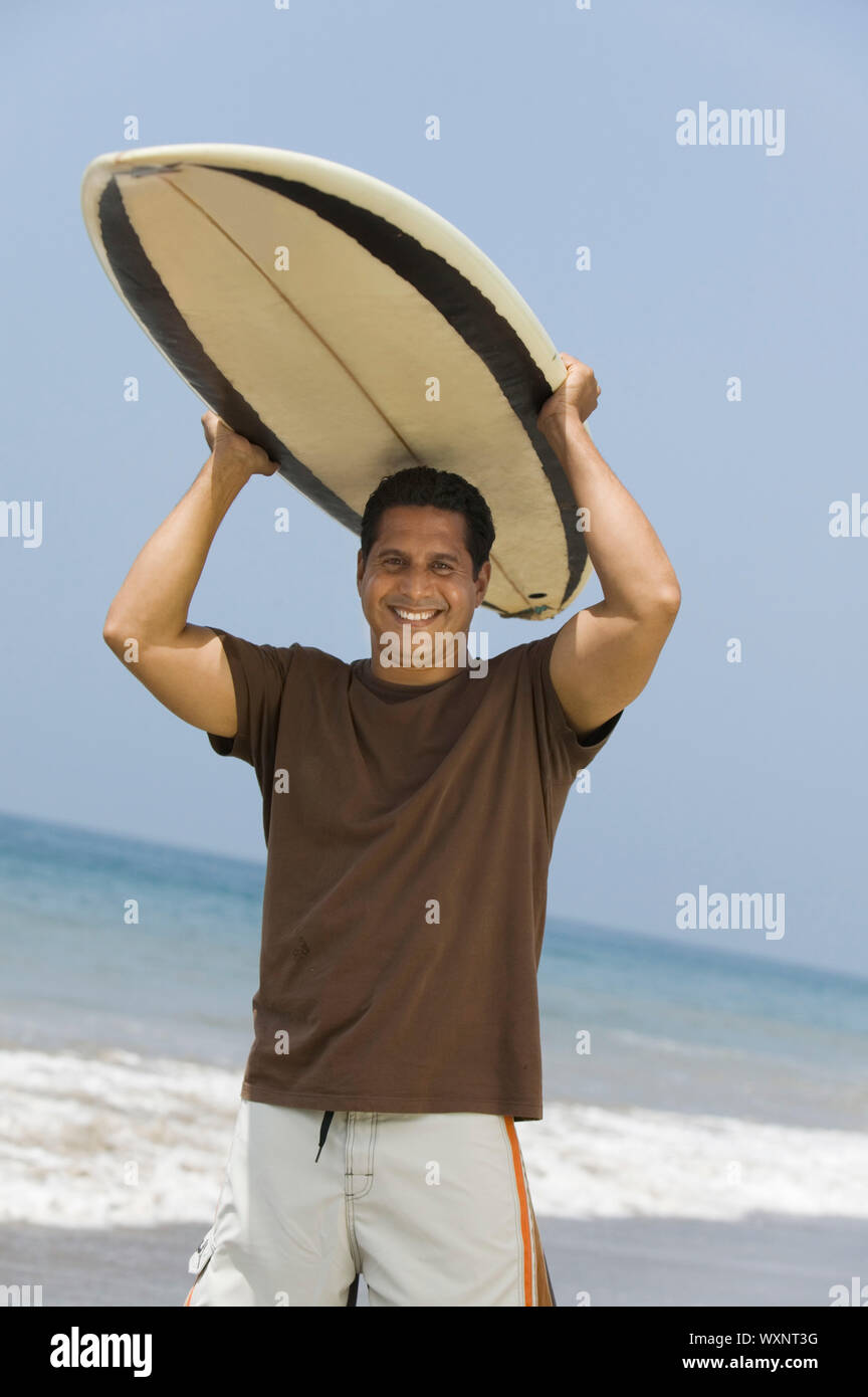 Man Carrying Surfboard Over His Head Stock Photo - Alamy