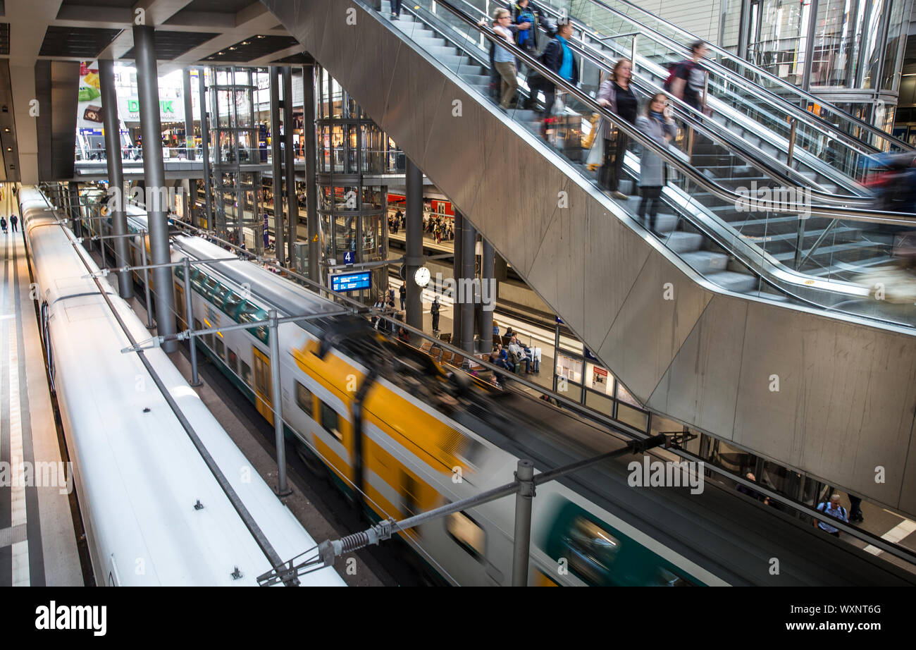 Passengers, and a train arriving at a platform inside the main train ...