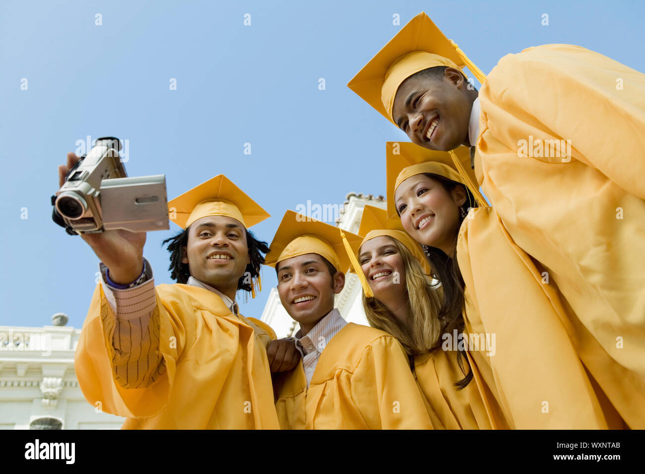 Graduates Looking at Video Camera Stock Photo - Alamy