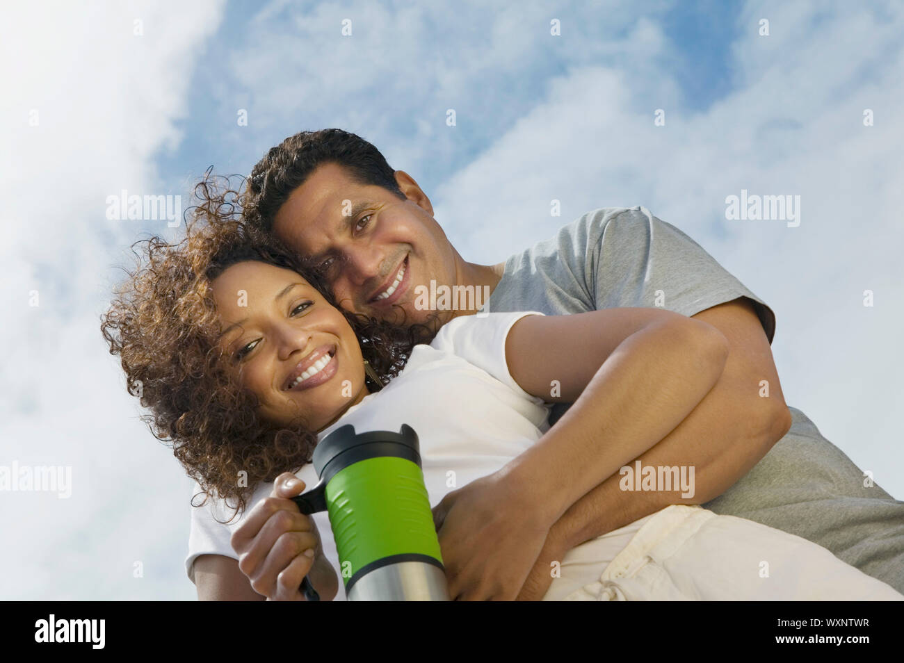 Couple Hugging and Holding Coffee Mug Stock Photo - Alamy
