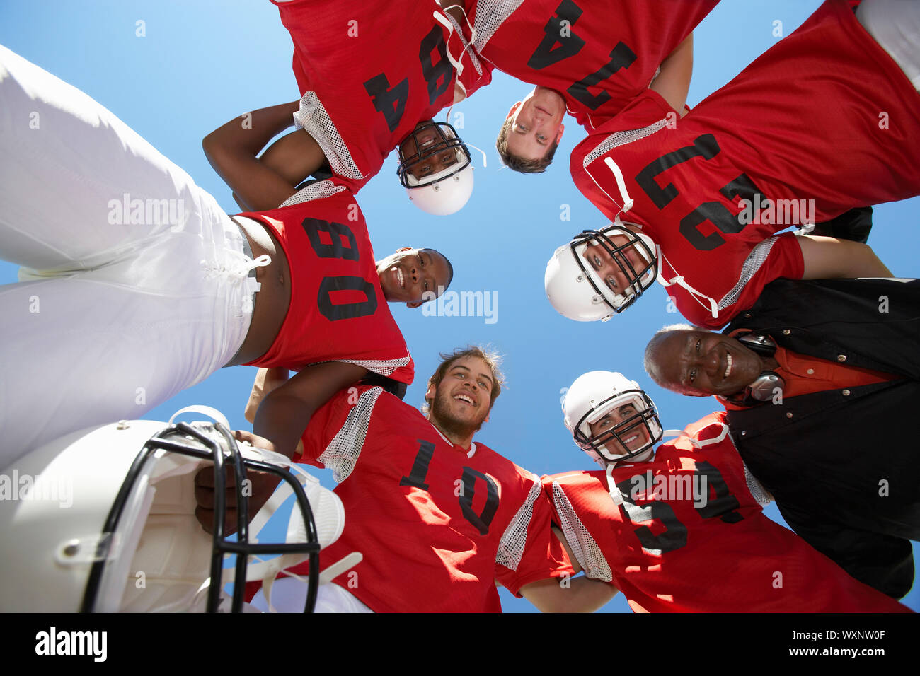 Football Players and Coach in Huddle Stock Photo - Alamy