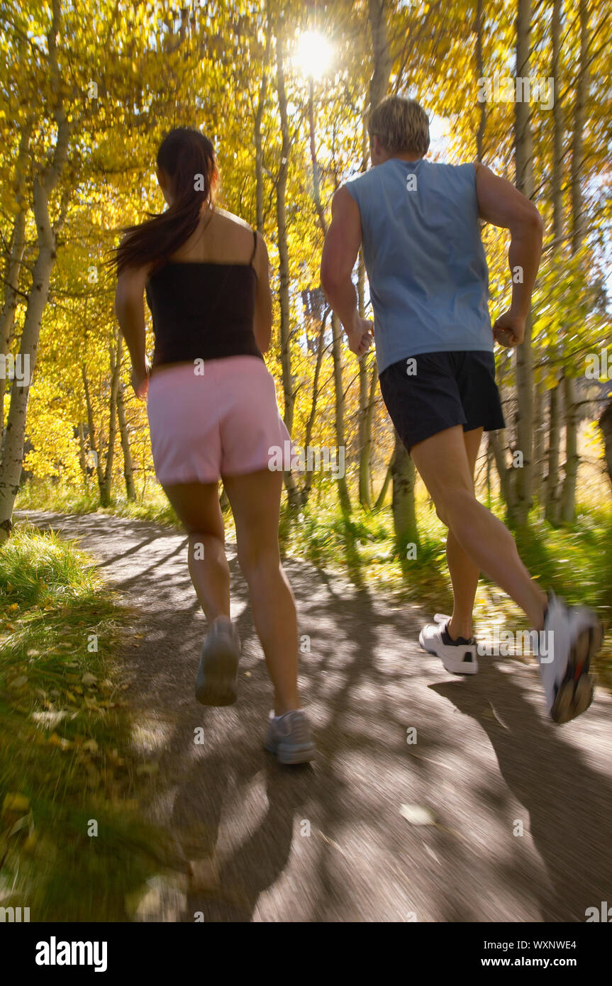 Couple Jogging Together on Path in Woods Stock Photo - Alamy