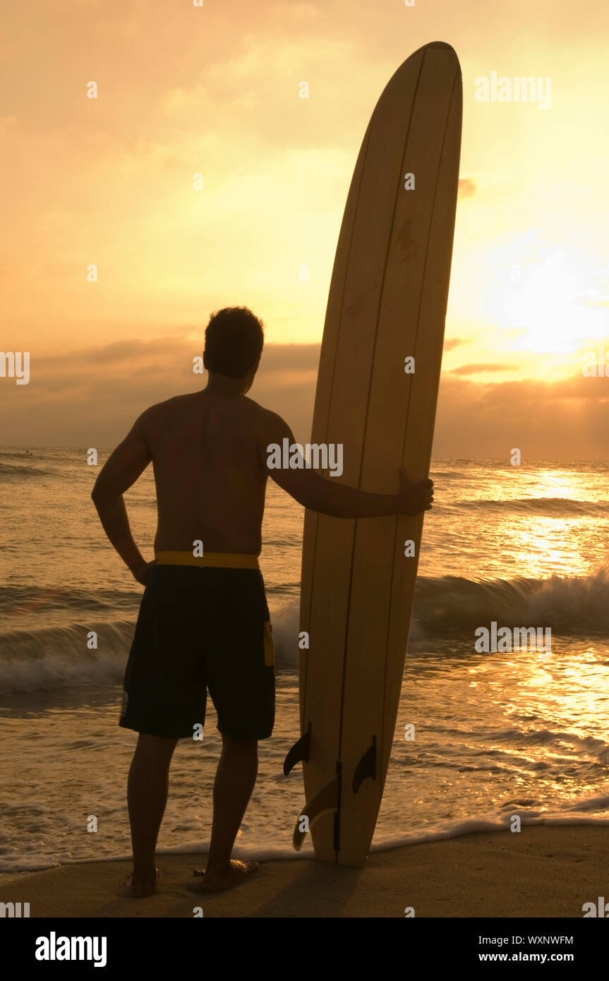 Longboard Surfer Enjoying Sunset on Beach Stock Photo - Alamy