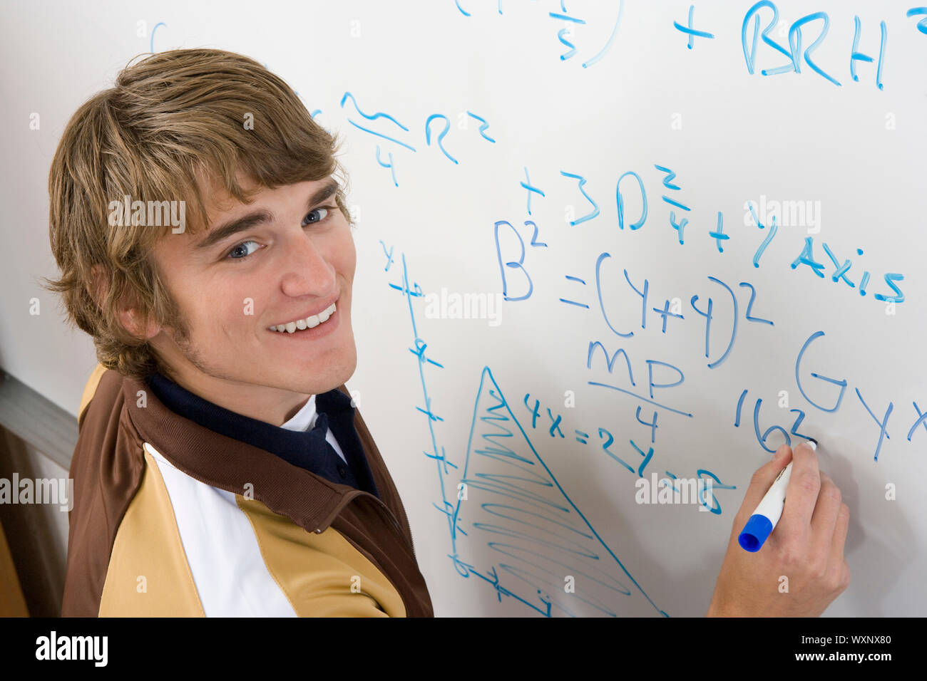Male student writing maths equations on whiteboard Stock Photo - Alamy