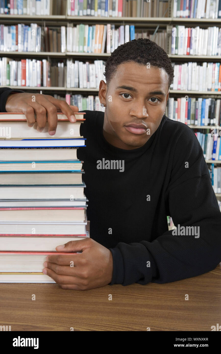 Student with a Stack of Books in the Library Stock Photo - Alamy