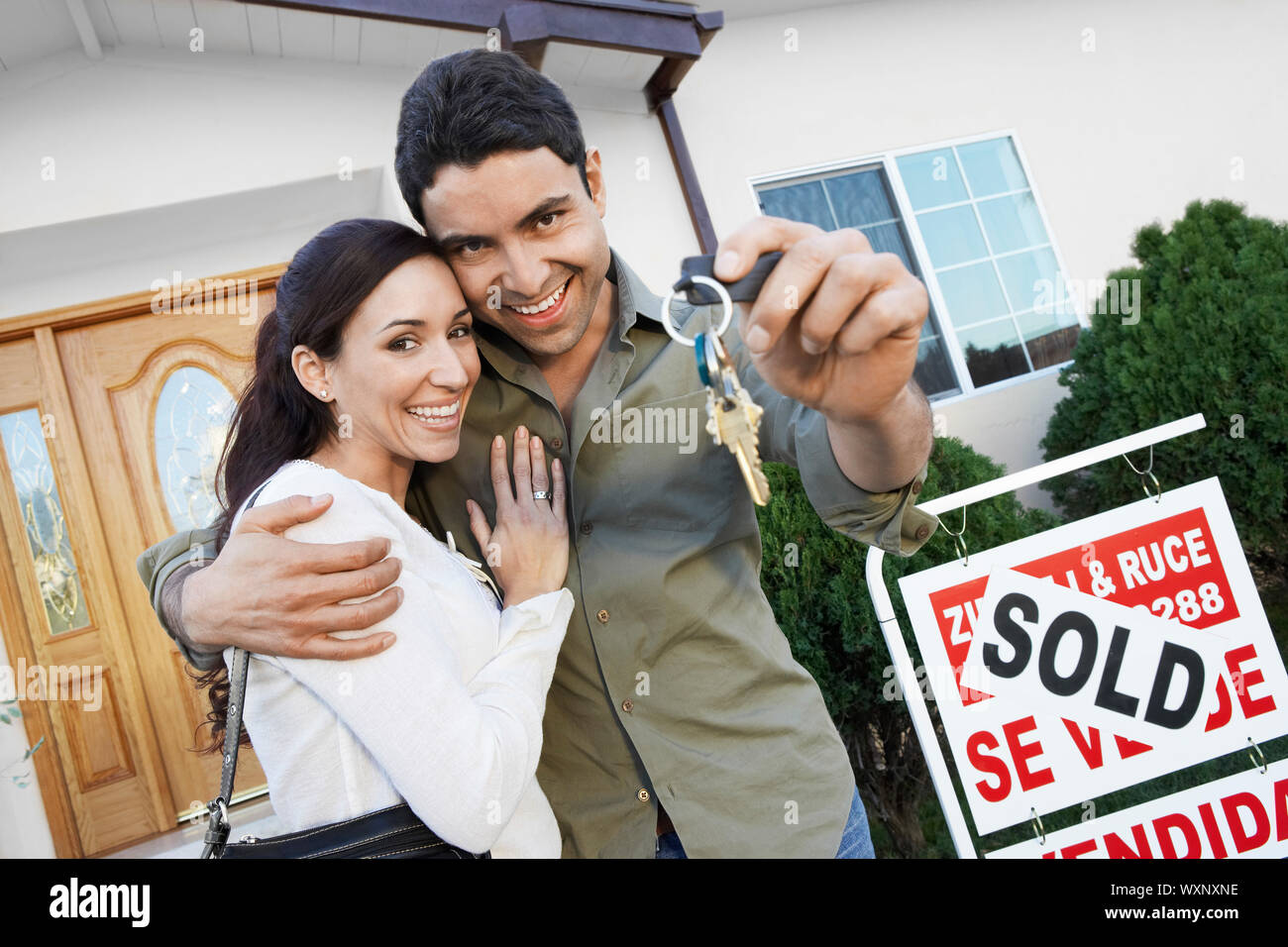 Happy Homeowners with Sign Stock Photo - Alamy