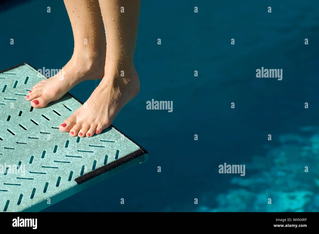 Female swimmer standing on diving board Stock Photo - Alamy
