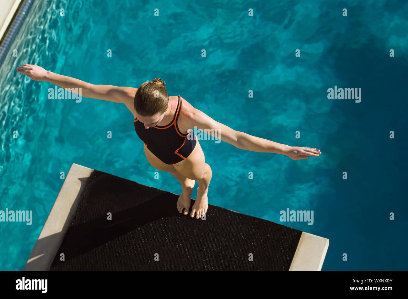 Female swimmer standing on diving board Stock Photo - Alamy
