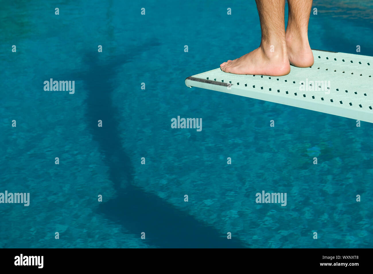 Male swimmer standing on diving board Stock Photo - Alamy