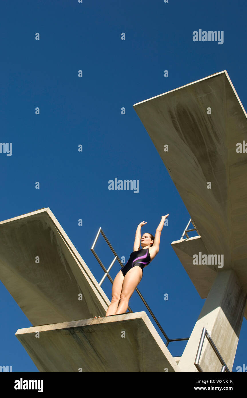 Female swimmer standing on diving board Stock Photo - Alamy
