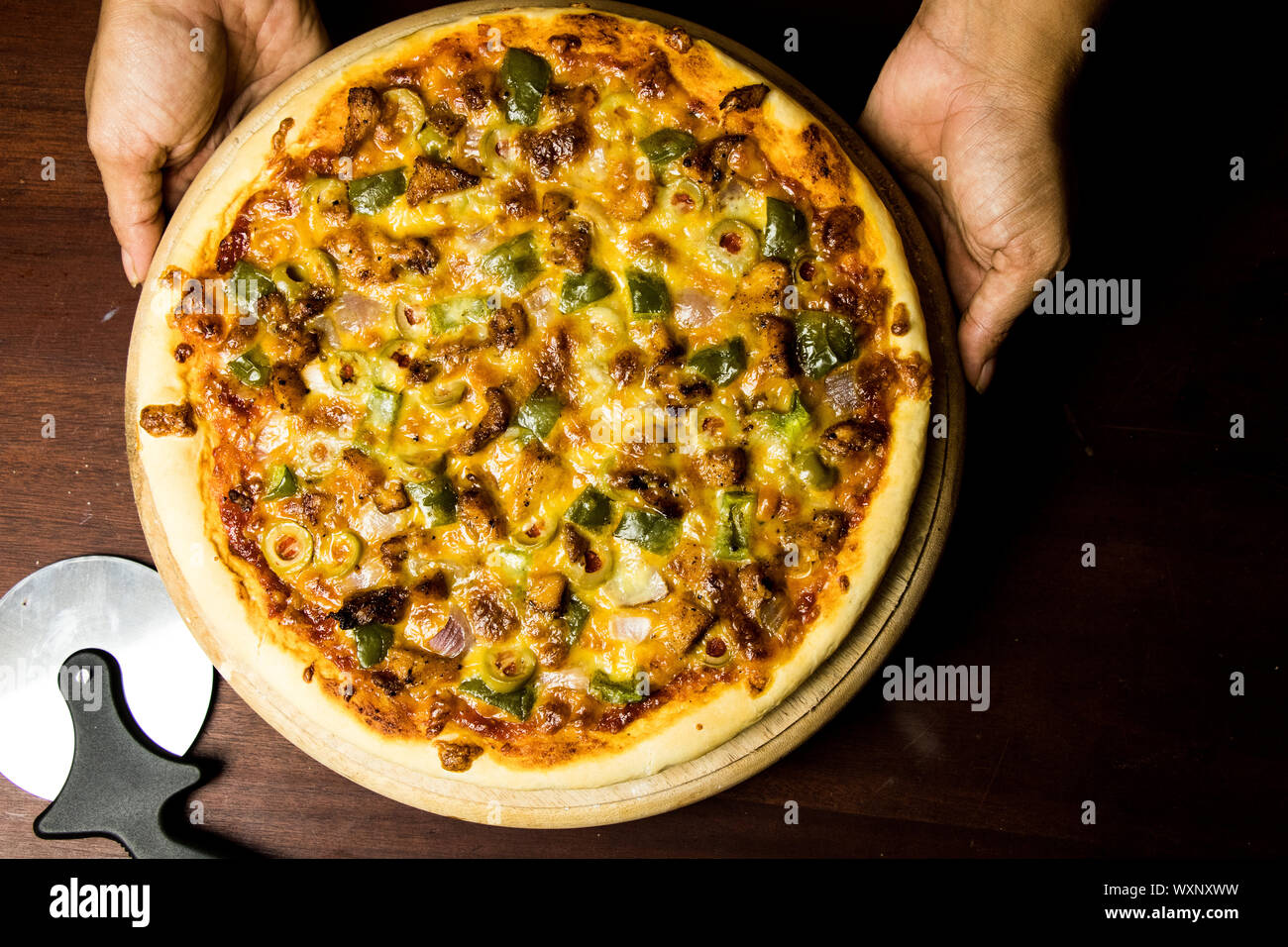 Pan Pizza take from top closeup hold hands and cutter Stock Photo - Alamy