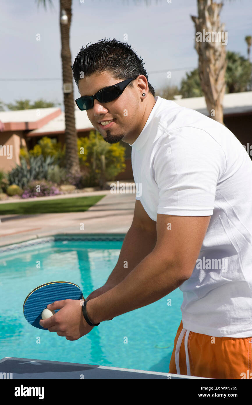 Young Man Playing Ping-Pong by Swimming Pool Stock Photo - Alamy
