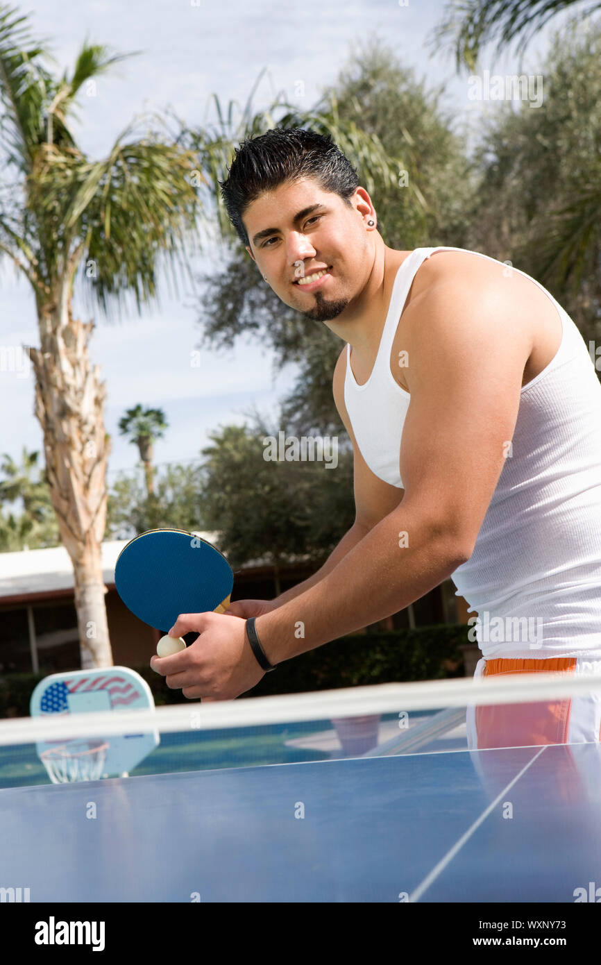 Young Man Playing Ping-Pong by Swimming Pool Stock Photo - Alamy