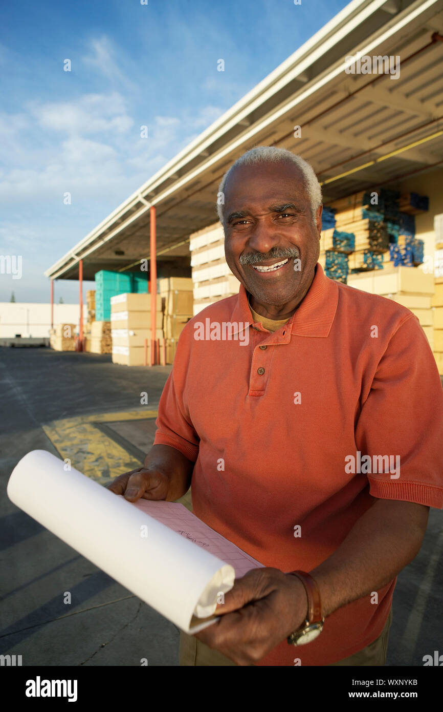 Manager with Paperwork by Loading Dock of Lumber Warehouse Stock Photo ...
