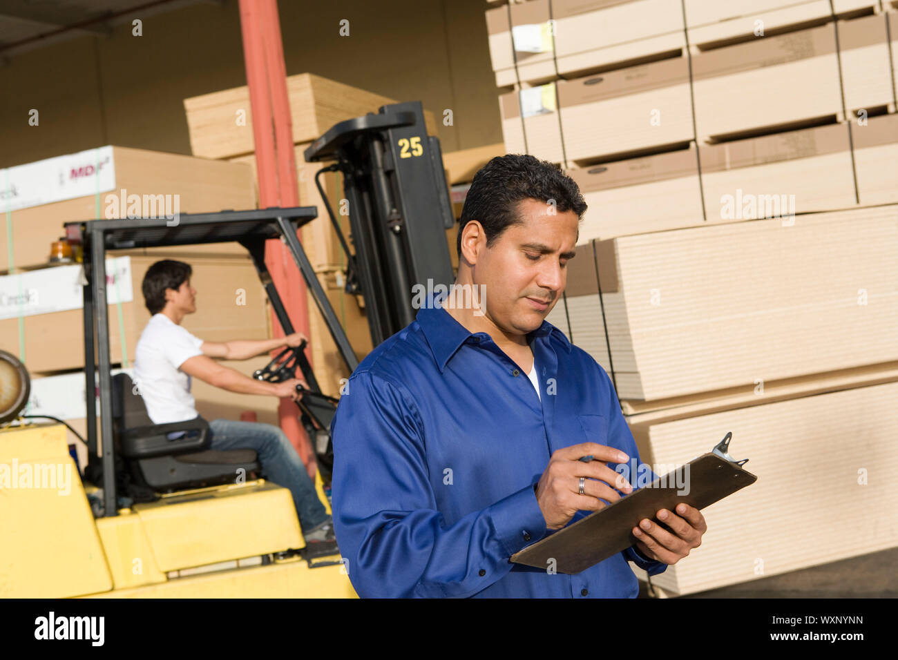 Warehouseman and forklift truck driver Stock Photo - Alamy