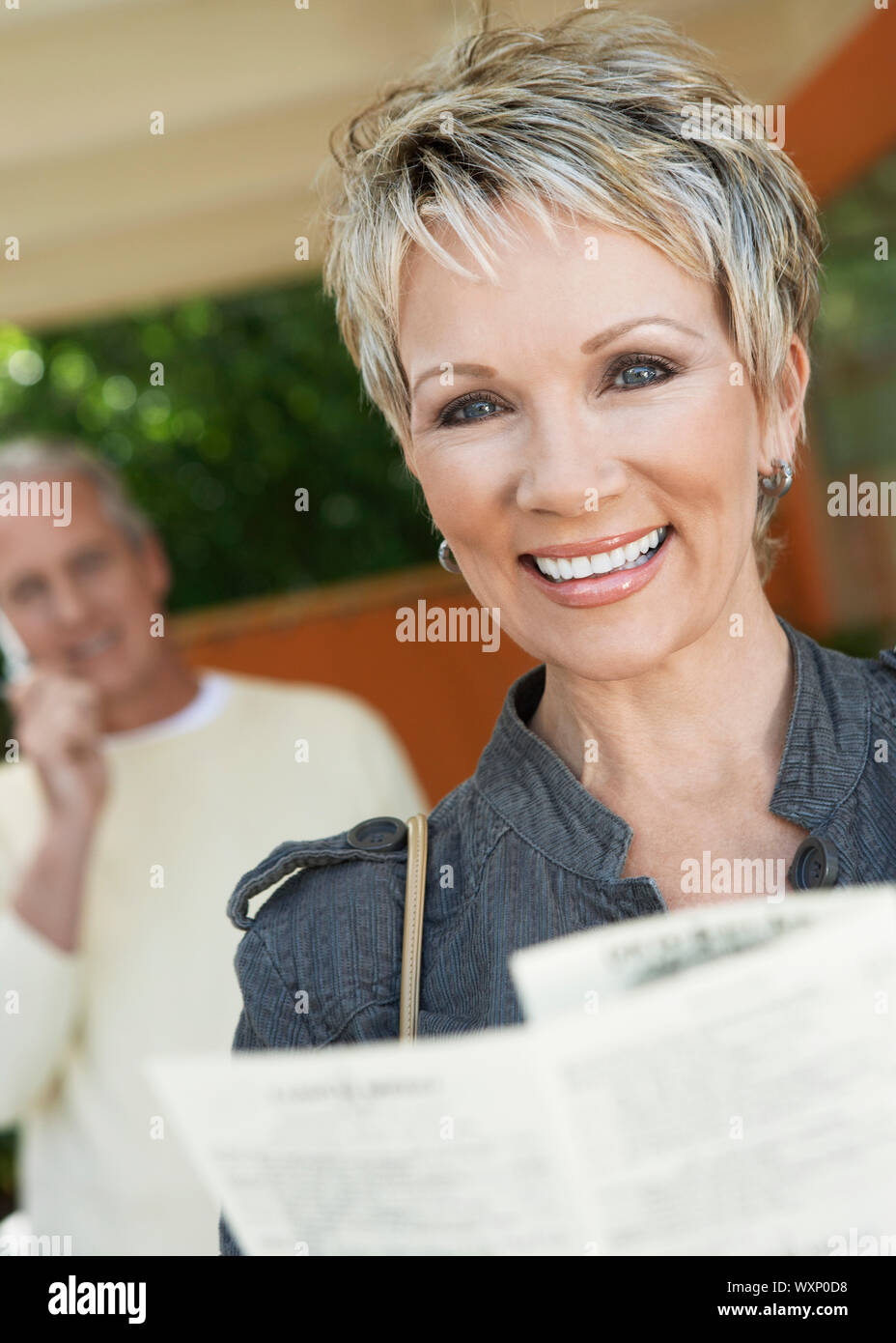 Smiling Woman Reading a Brochure Stock Photo - Alamy