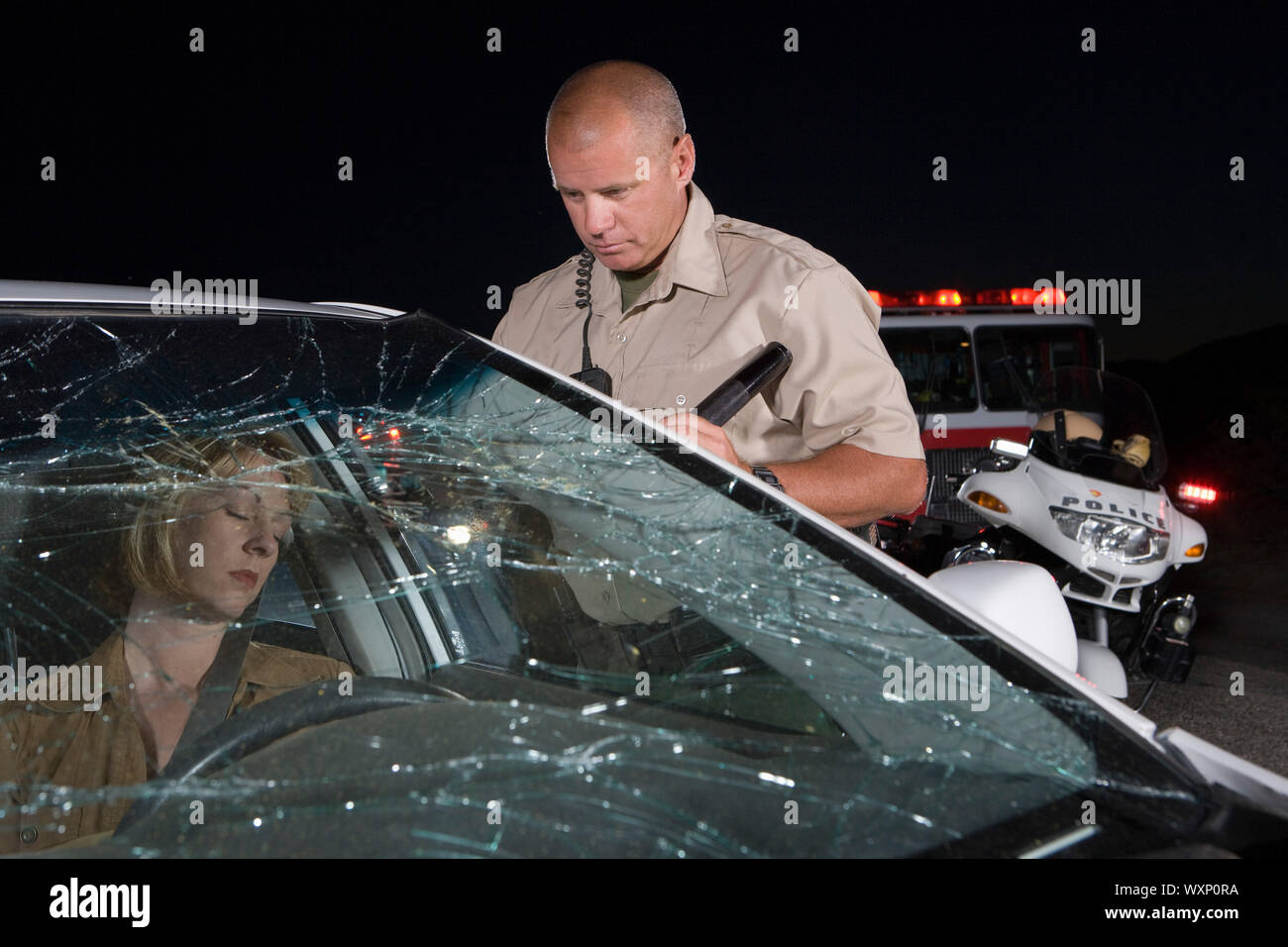 Police officer rescuing car accident victim Stock Photo - Alamy