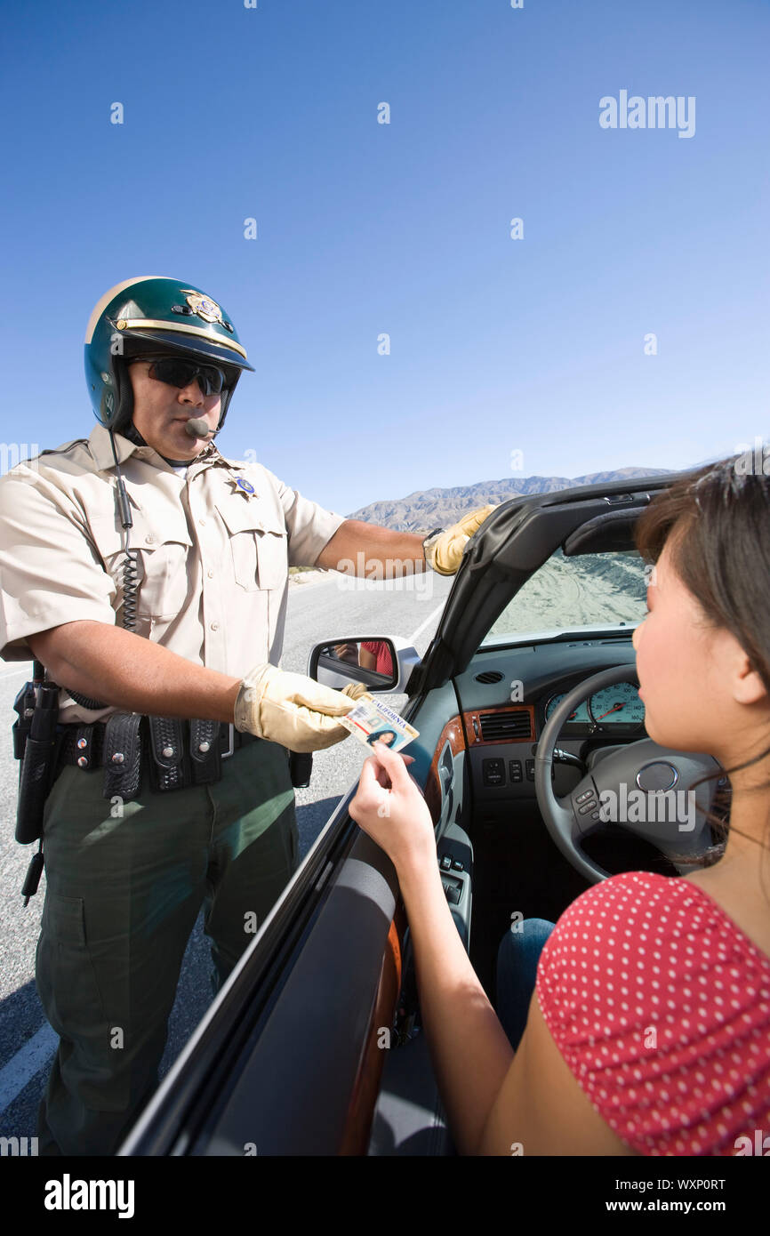 Police officer checking driver's ID Stock Photo - Alamy