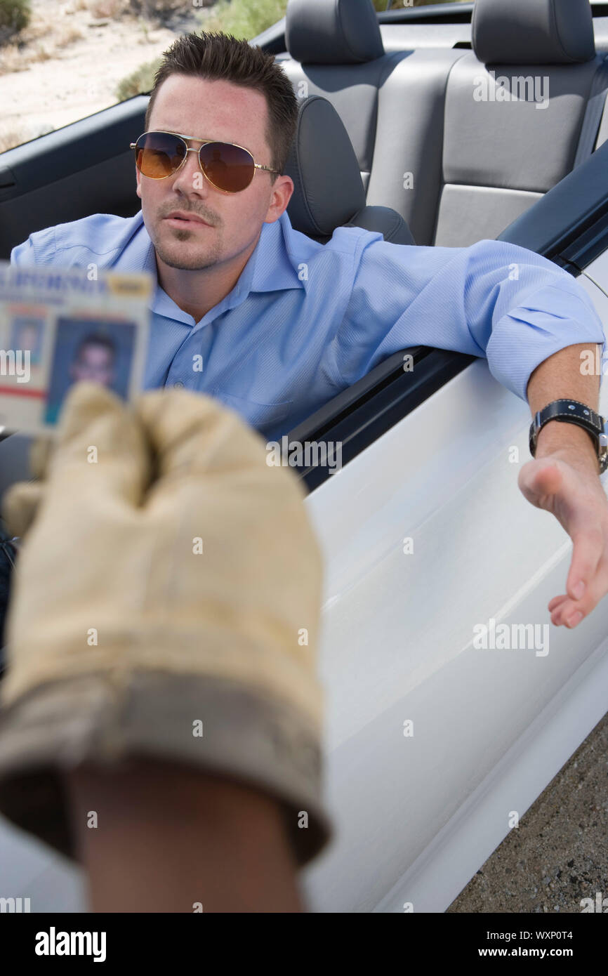 Police officer checking driver's ID Stock Photo - Alamy