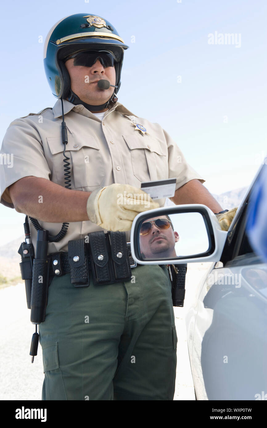 Police officer checking driver's ID Stock Photo - Alamy