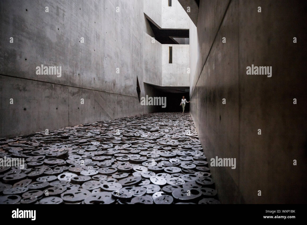 A woman walking on the Fallen Leaves installation in the Memory Void at ...