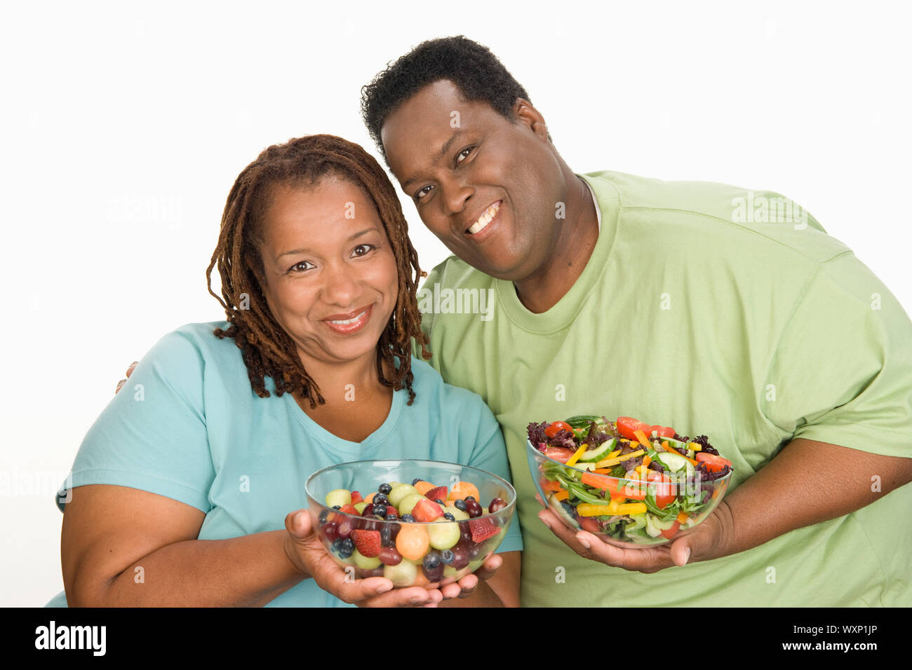 Mid-adult overweight woman and mid-adult overweight man holding bowls ...