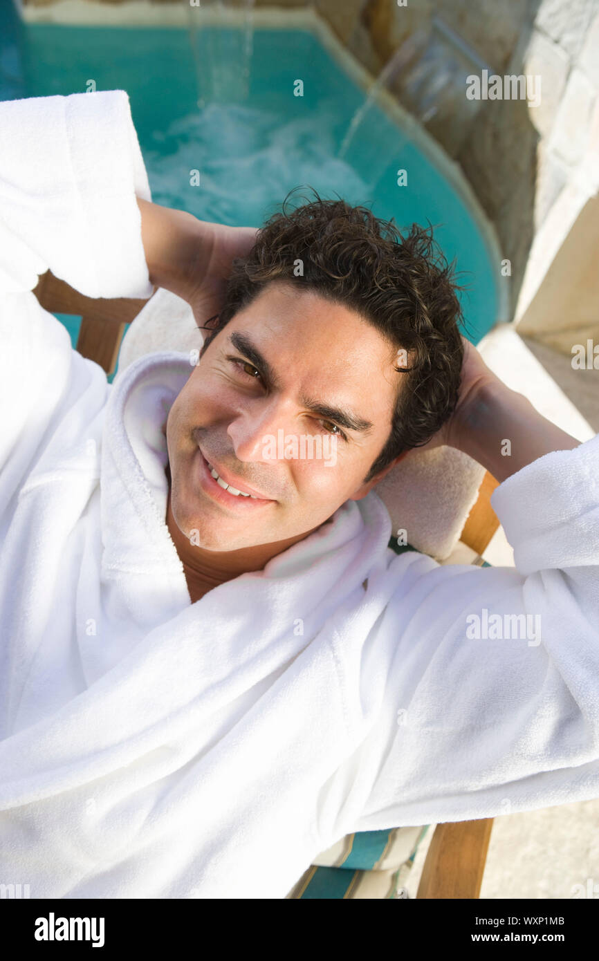 Portrait of man relaxing by swimming pool Stock Photo - Alamy