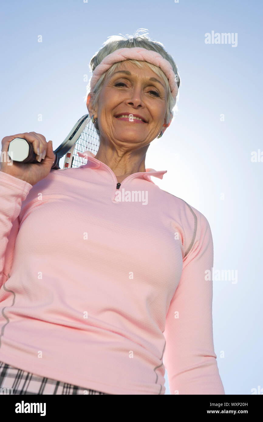 Senior woman holding tennis racket, portrait Stock Photo - Alamy