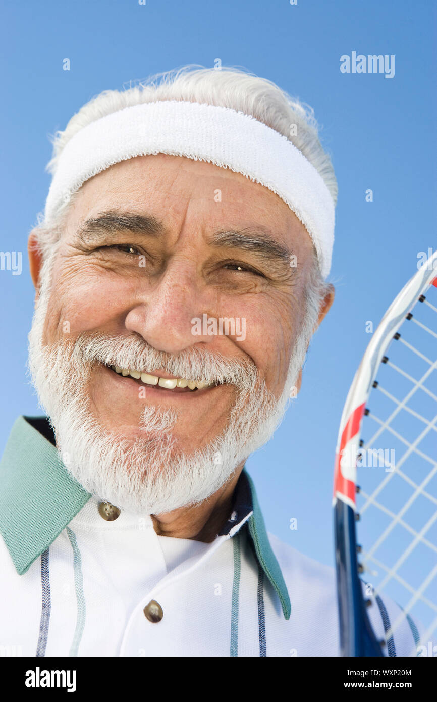 Senior man holding tennis racket, portrait Stock Photo - Alamy