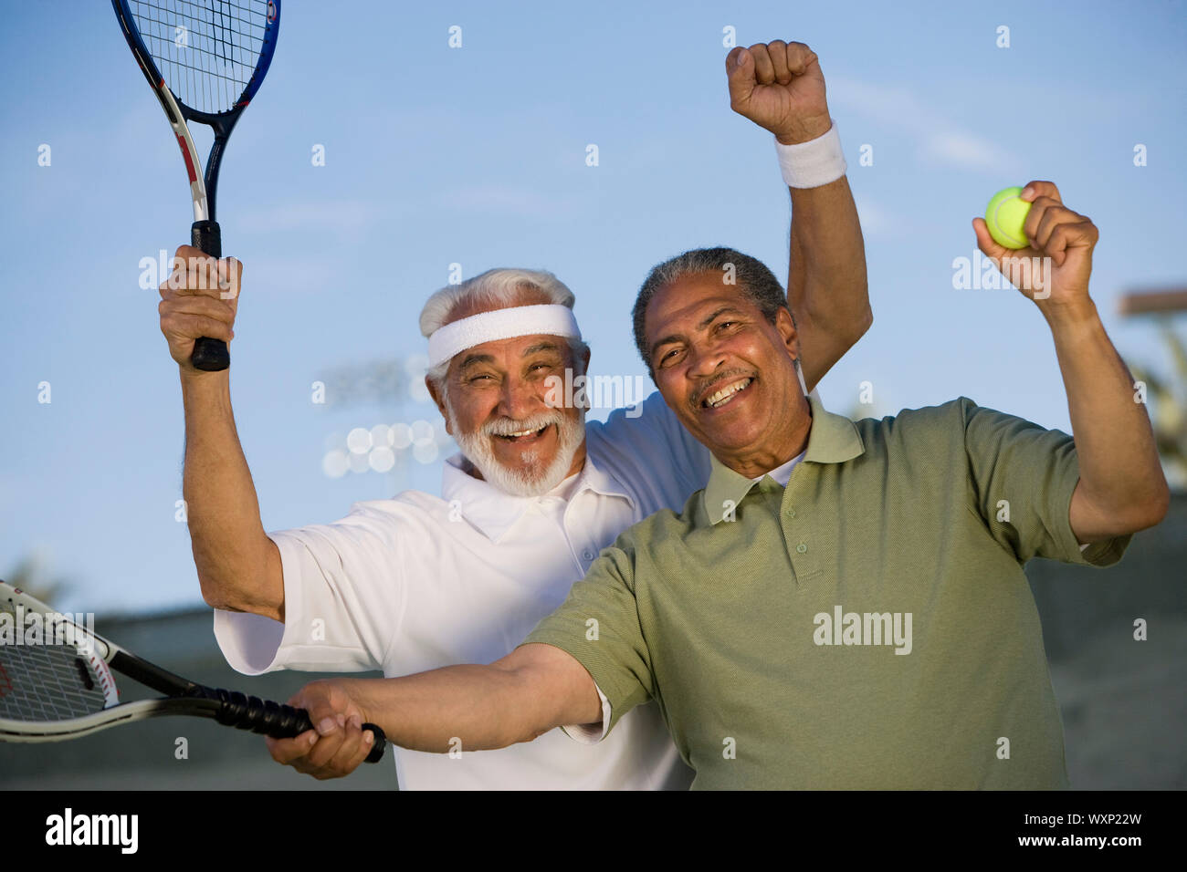 Two male tennis players cheering on court Stock Photo - Alamy