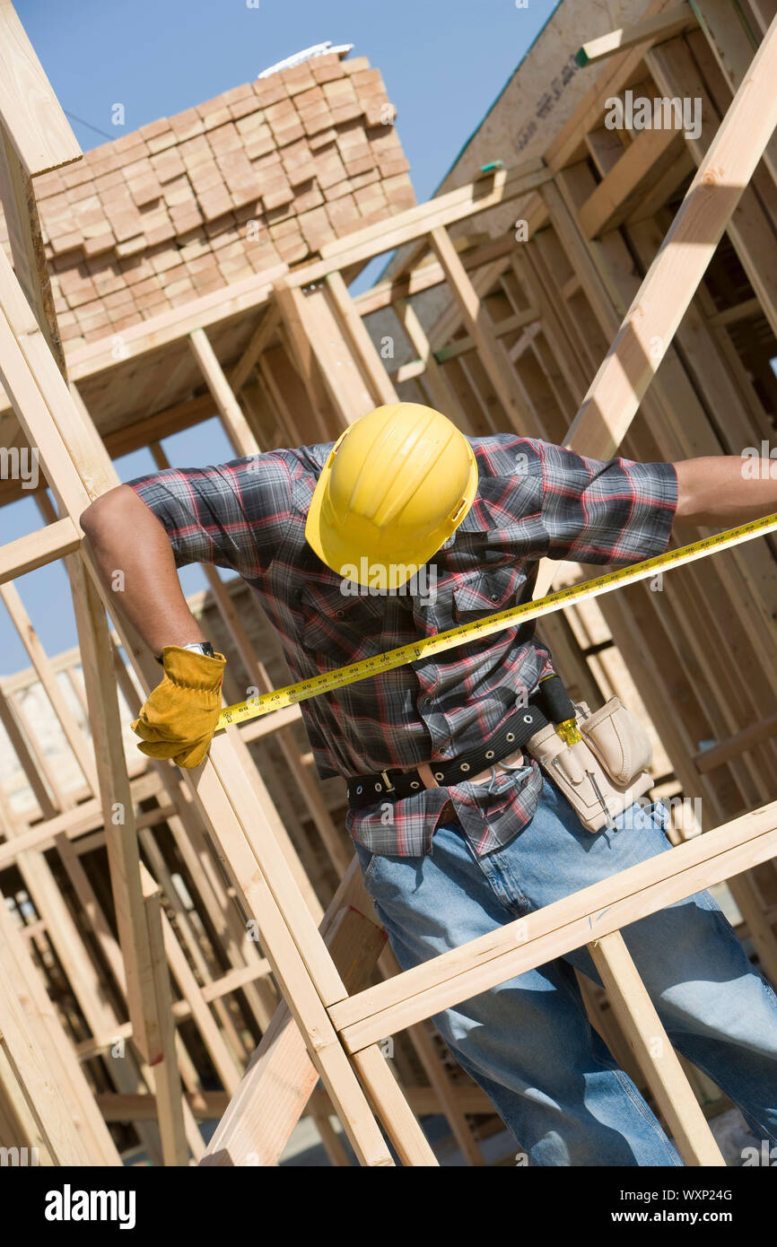Construction worker measuring building Stock Photo - Alamy