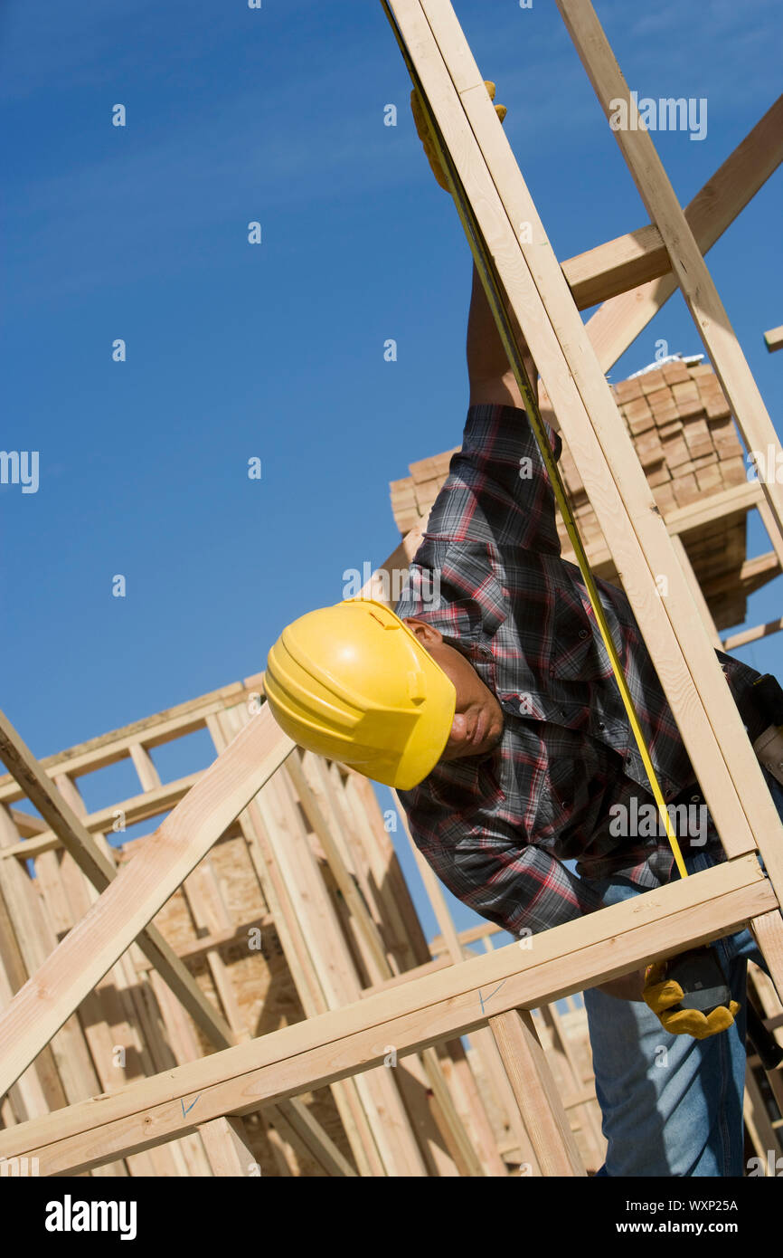 Construction worker measuring building Stock Photo - Alamy