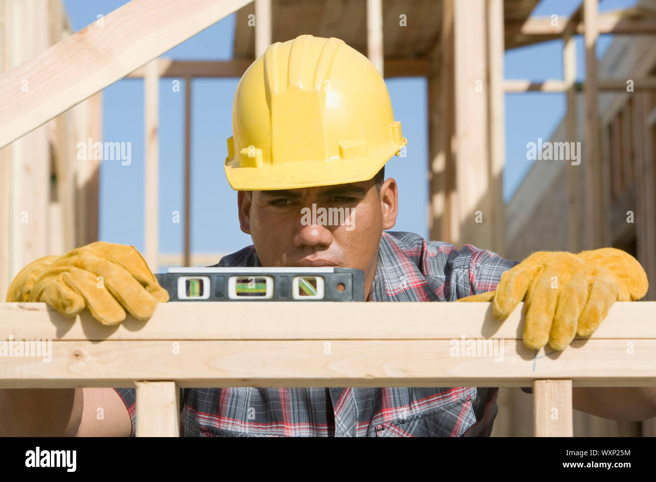 Construction worker using spirit level on building Stock Photo - Alamy