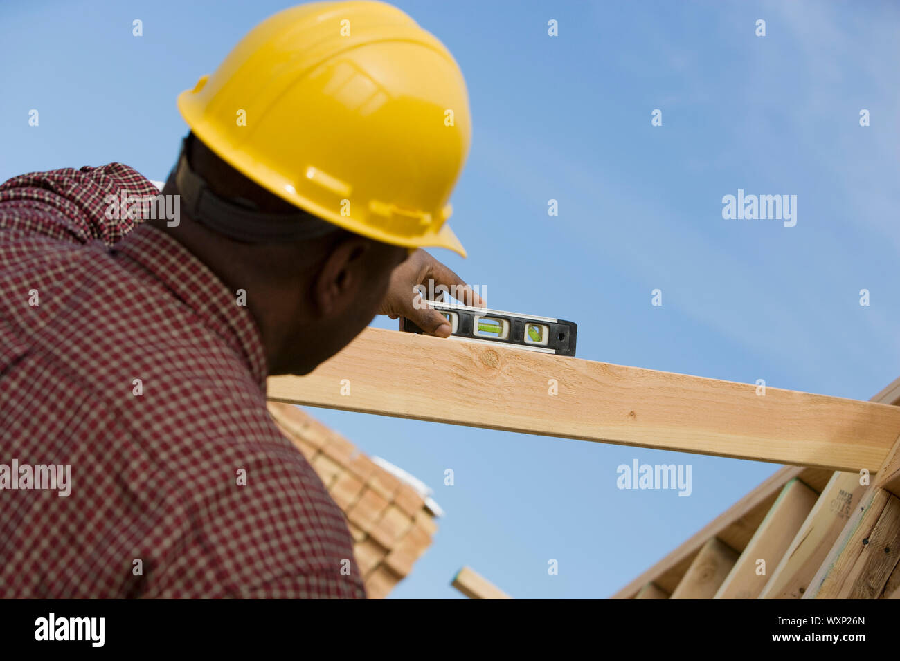 Construction worker using spirit level on building Stock Photo - Alamy