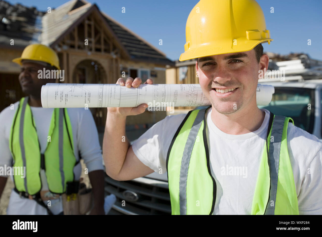 Construction worker holding blueprint, portrait Stock Photo - Alamy