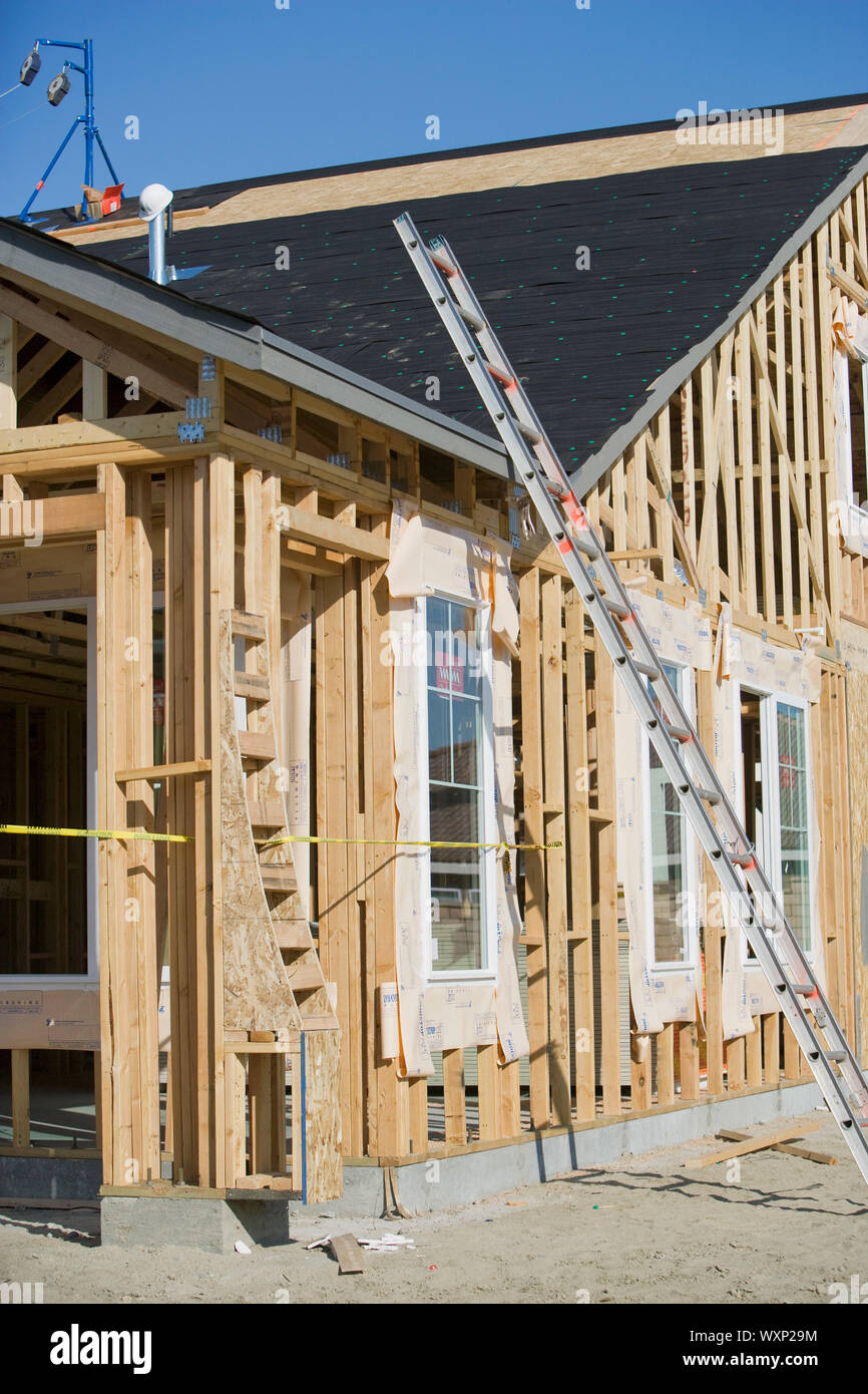 Ladder against wooden house construction Stock Photo - Alamy