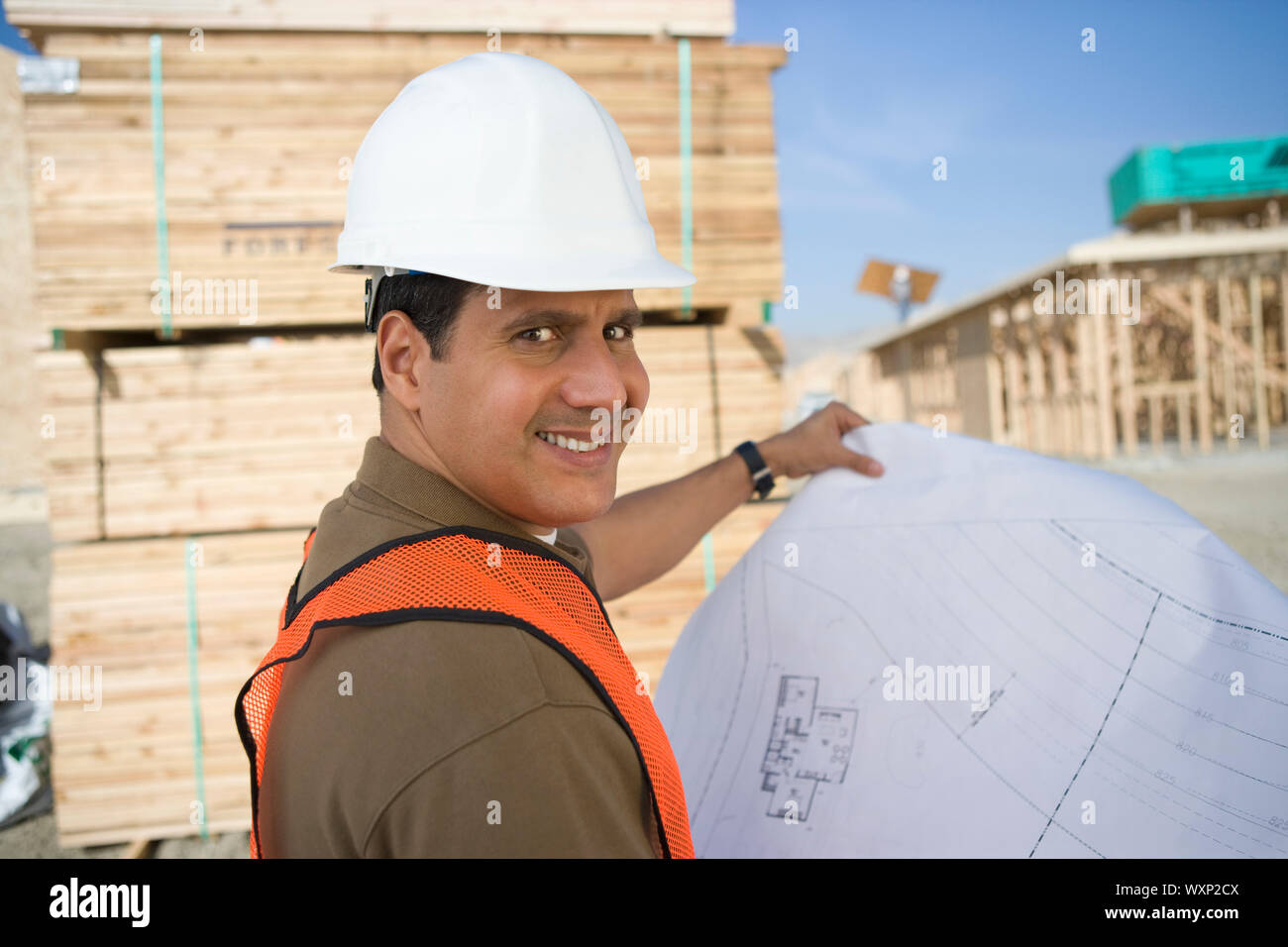 Construction worker standing on construction site and holding ...