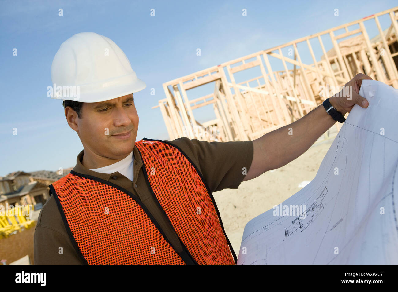 Construction worker standing on construction site and holding ...
