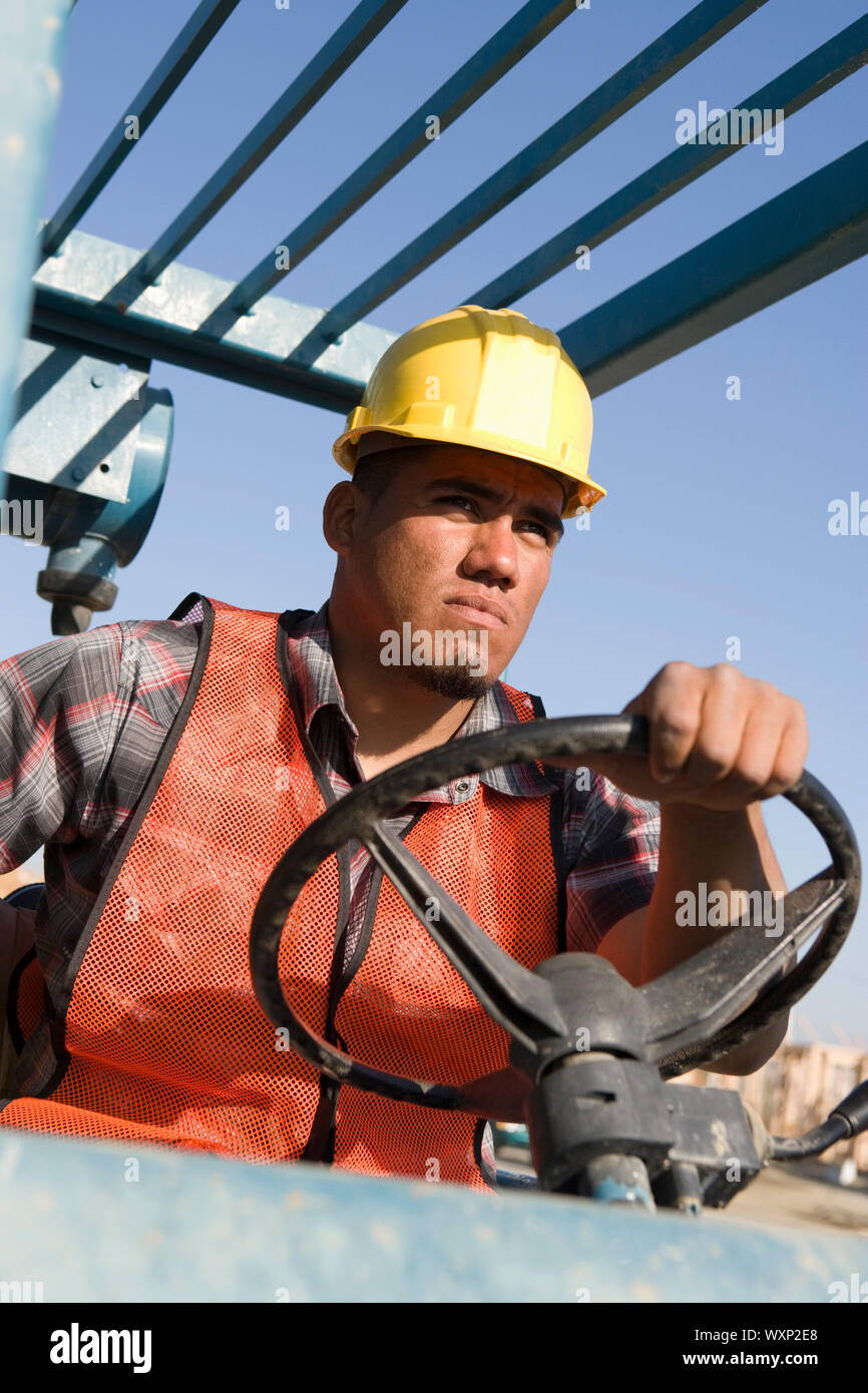 Construction worker driving vehicle Stock Photo - Alamy