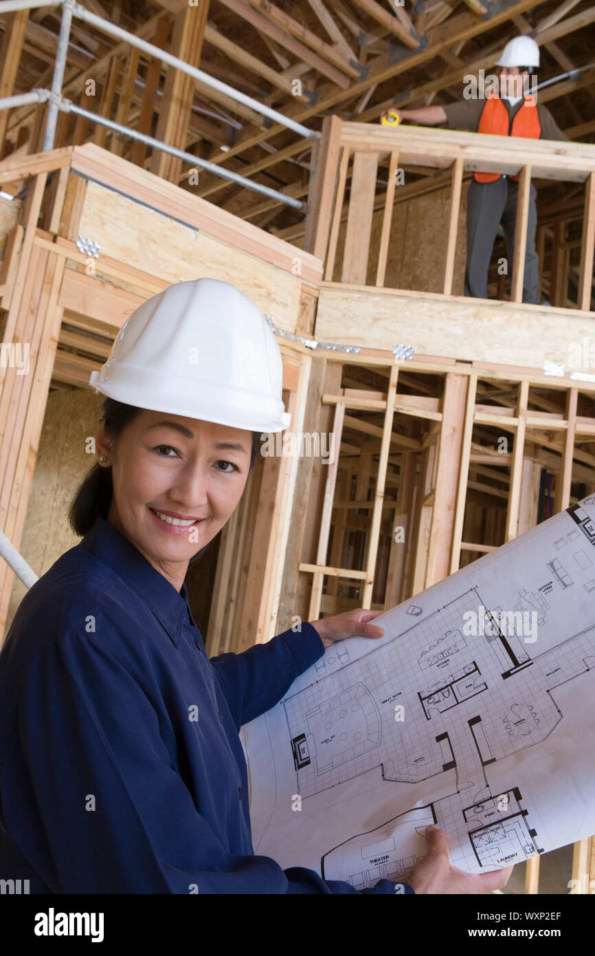 Architect and construction worker examining half constructed house ...
